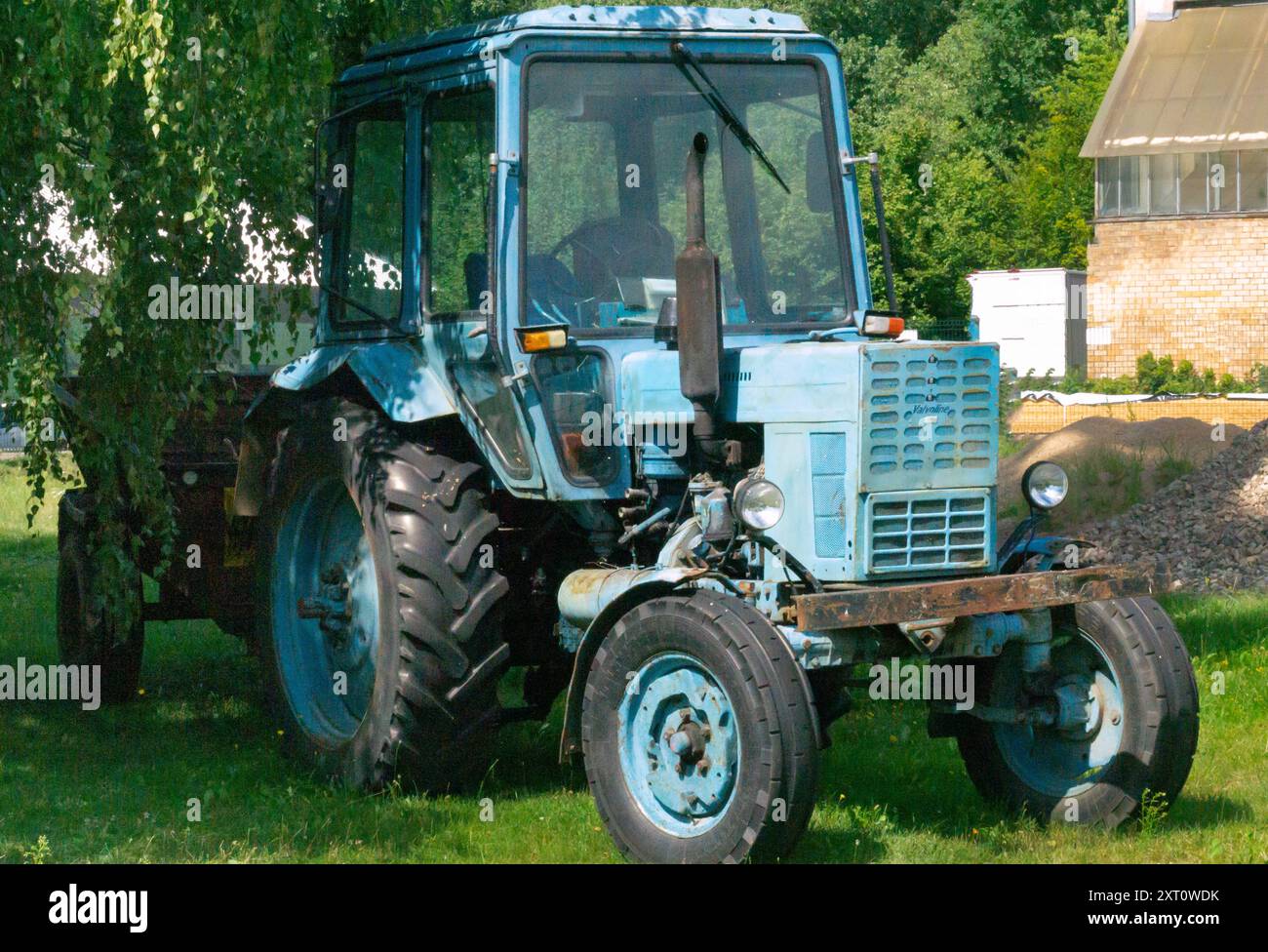 An old rusty blue tractor under a birch tree Stock Photo - Alamy