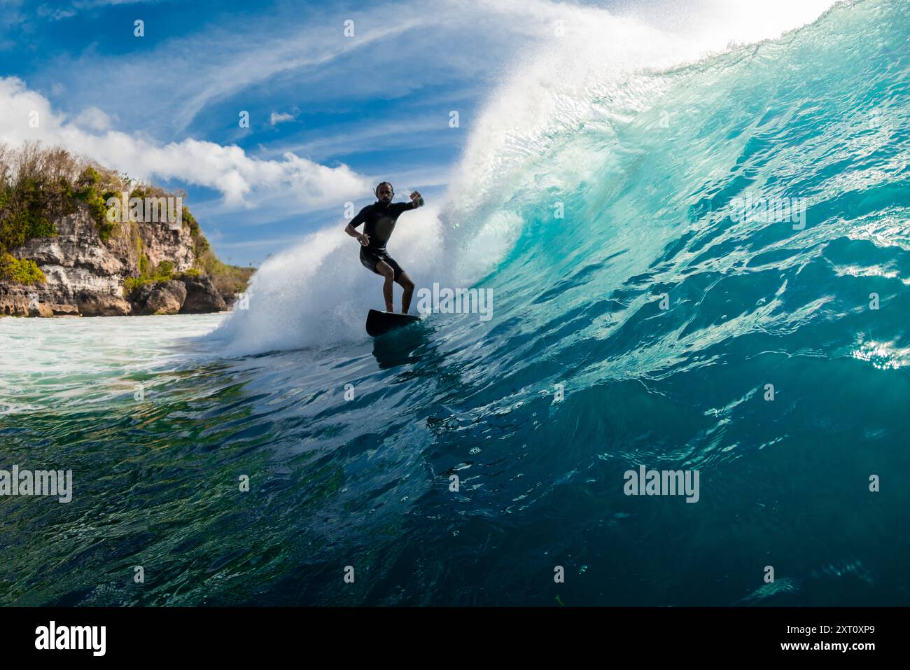 August 08, 2024. Bali, Indonesia. Surfer on surfboard ride at blue ...