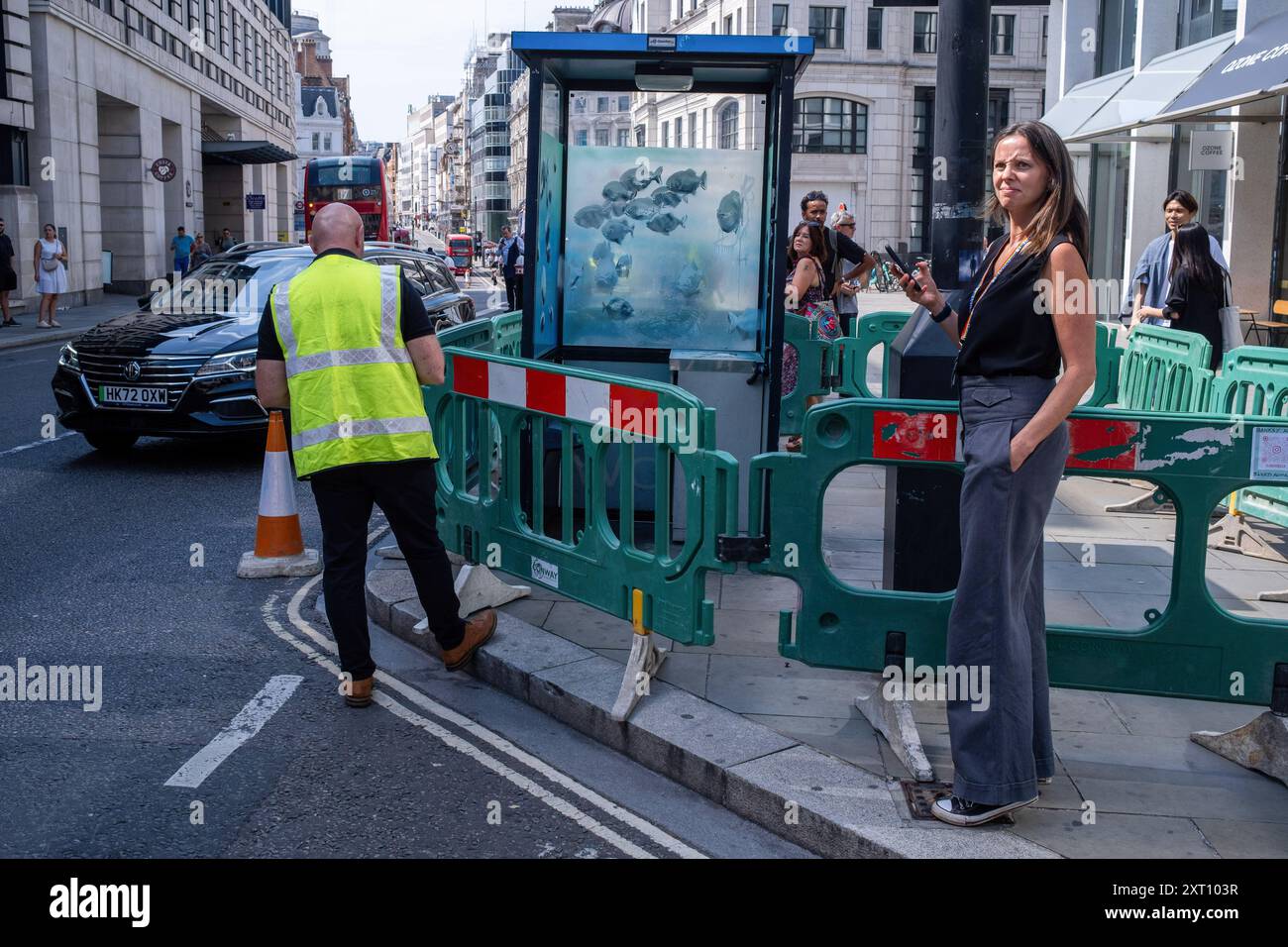 A woman stands in front of Banksy's fish tank mural. Members of the ...