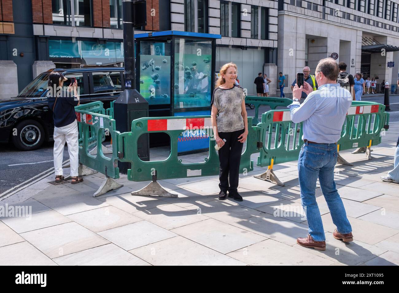 A woman poses for a photograph in front of Banksy's fish tank mural ...