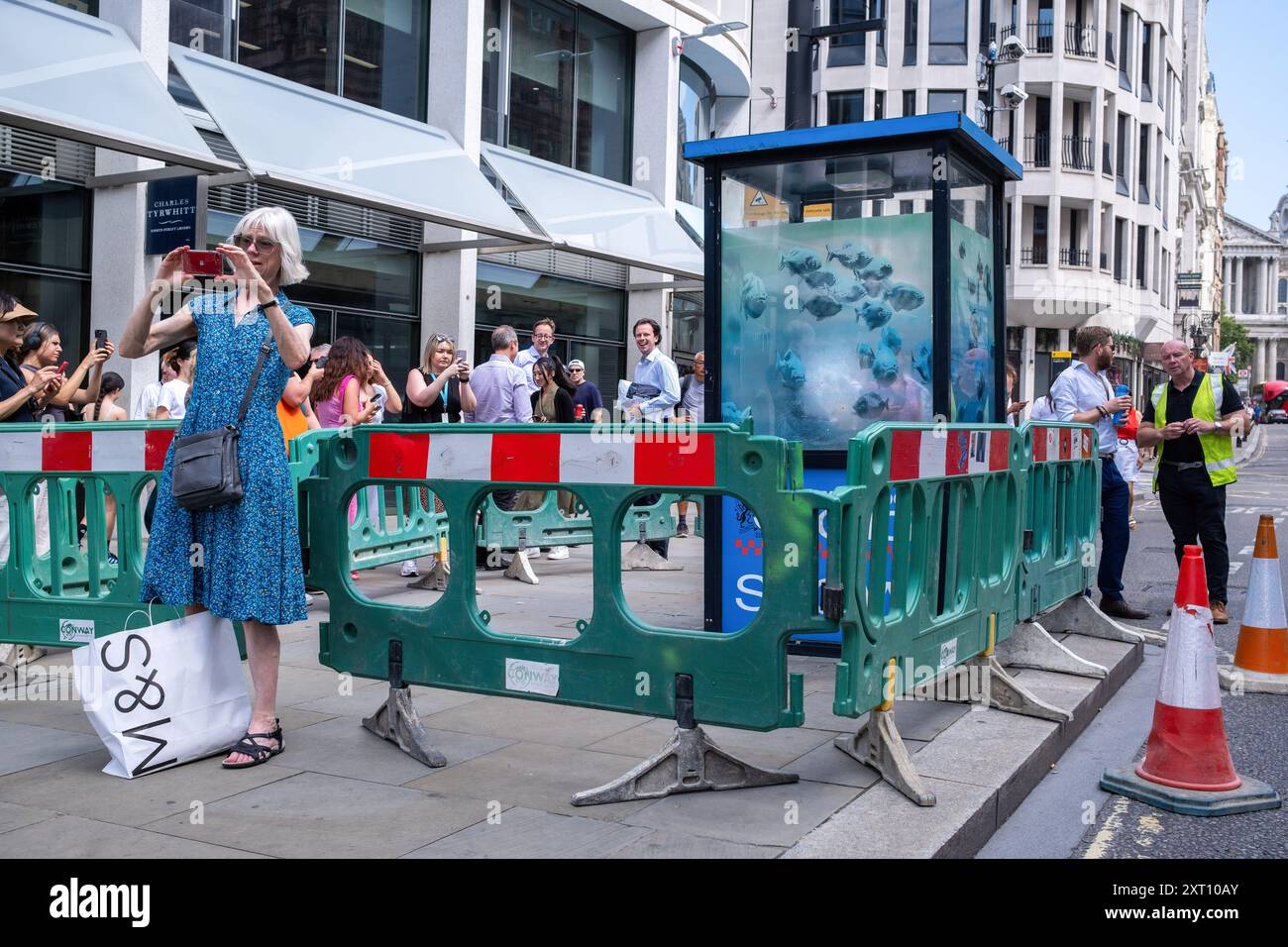 A woman stands in front of a piece of art and takes a selfie on her ...