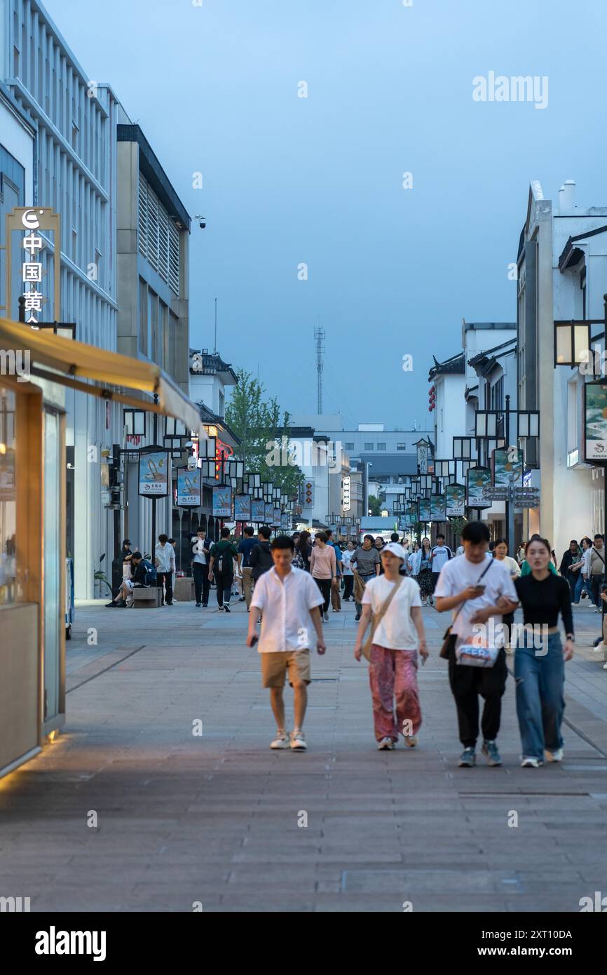 Suzhou, China - June 11, 2024 : People walk along a bustling street ...