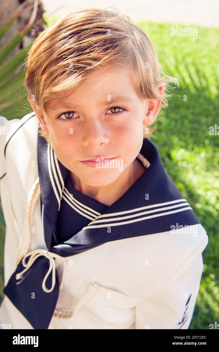 A portrait of a young boy with a thoughtful expression, dressed in ...