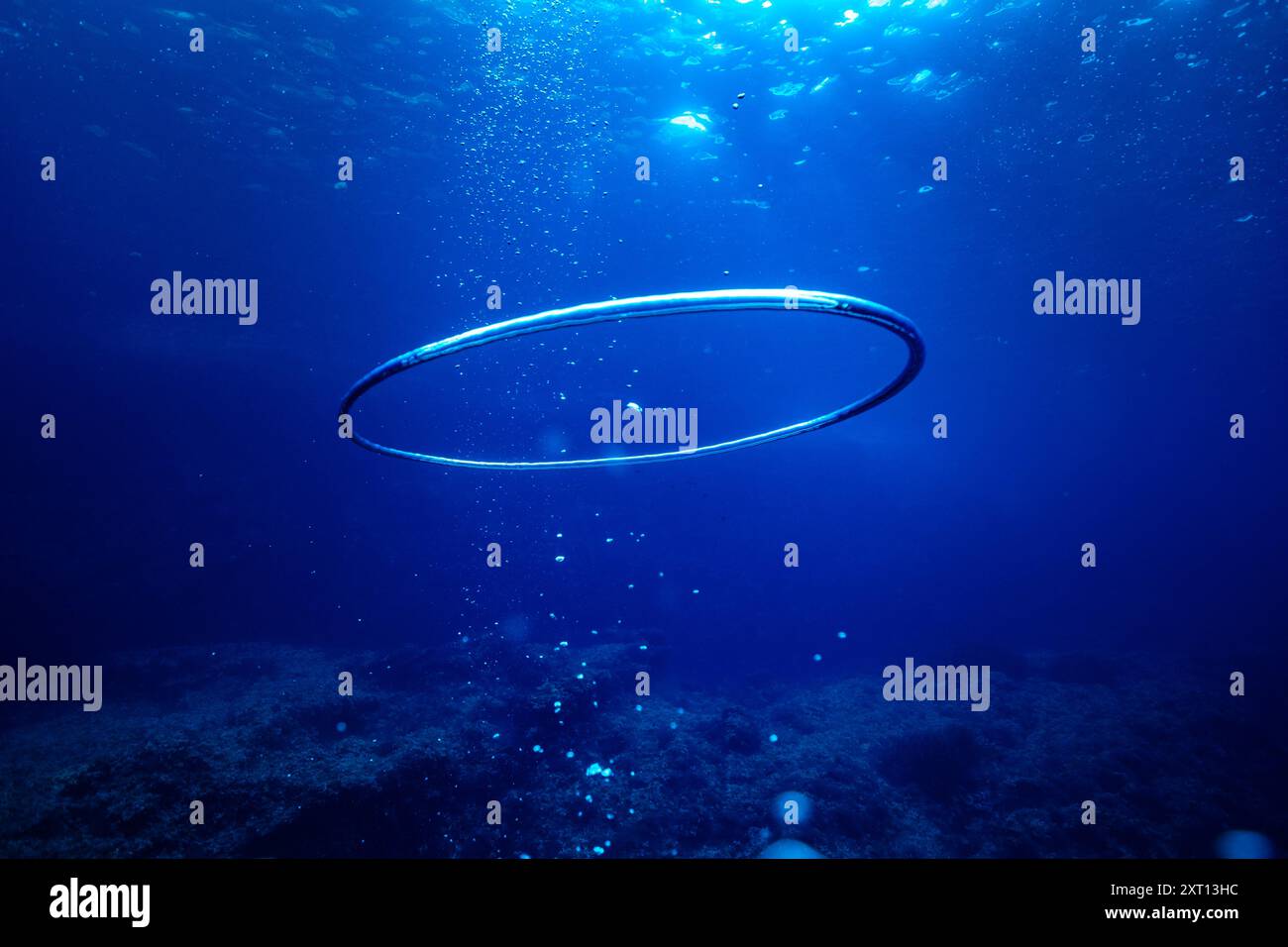 Underwater view of air ring and bubbles floating in transparent crystal ...