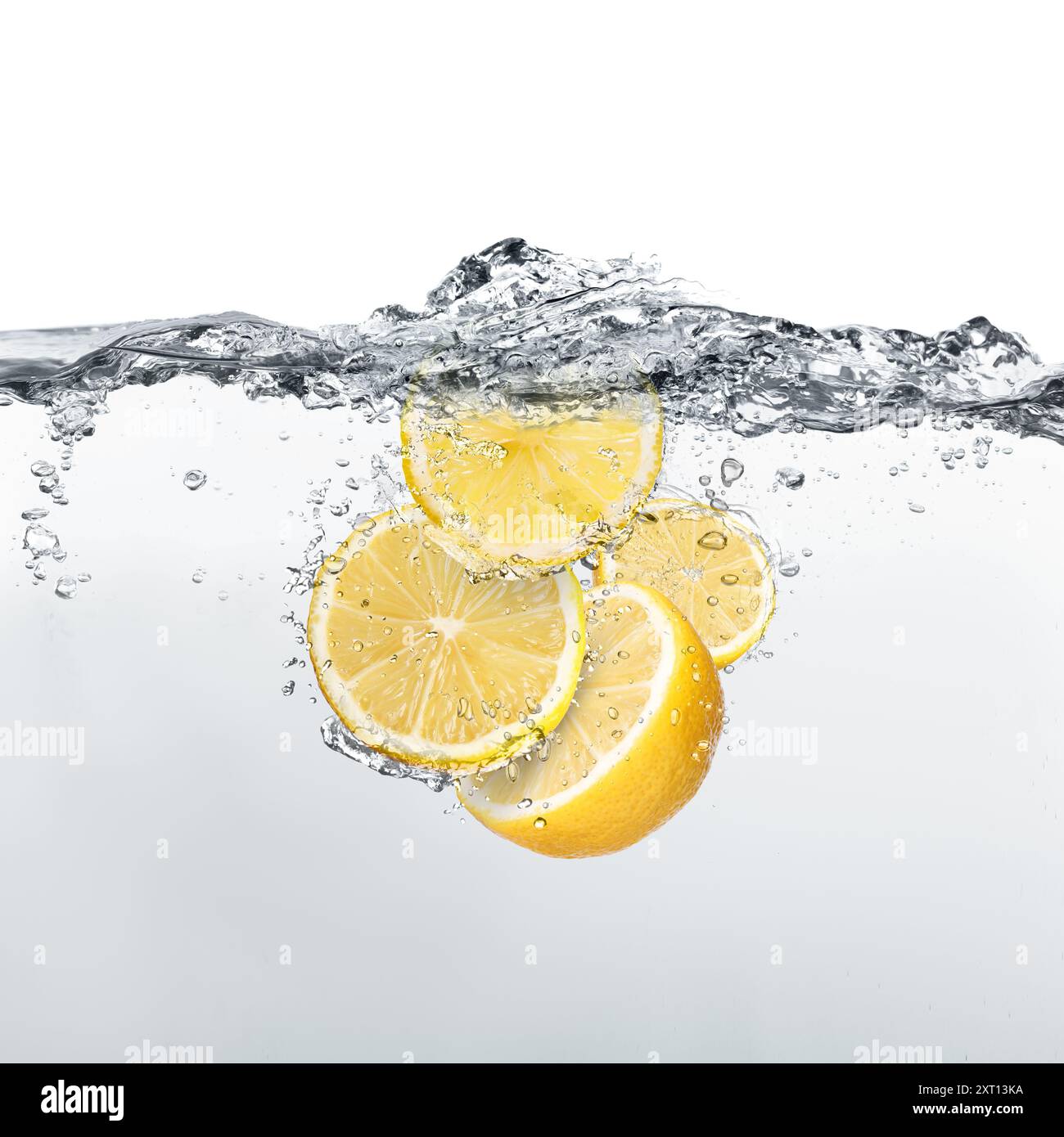 Fresh lemons falling into water on white background Stock Photo - Alamy