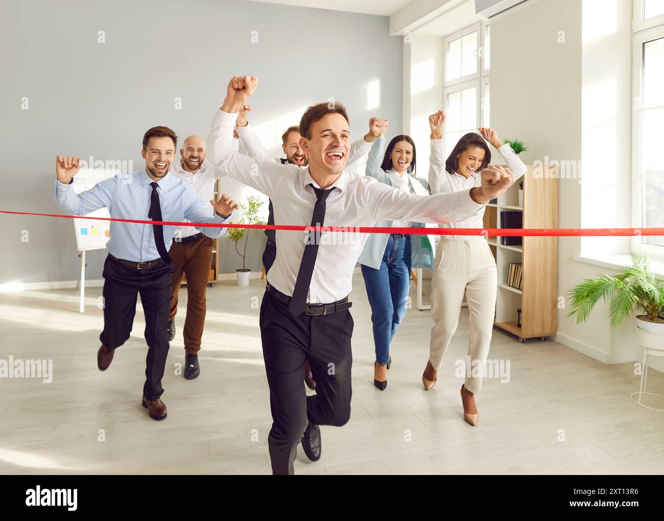 Happy office contest, business people crossing red marathon ribbon ...