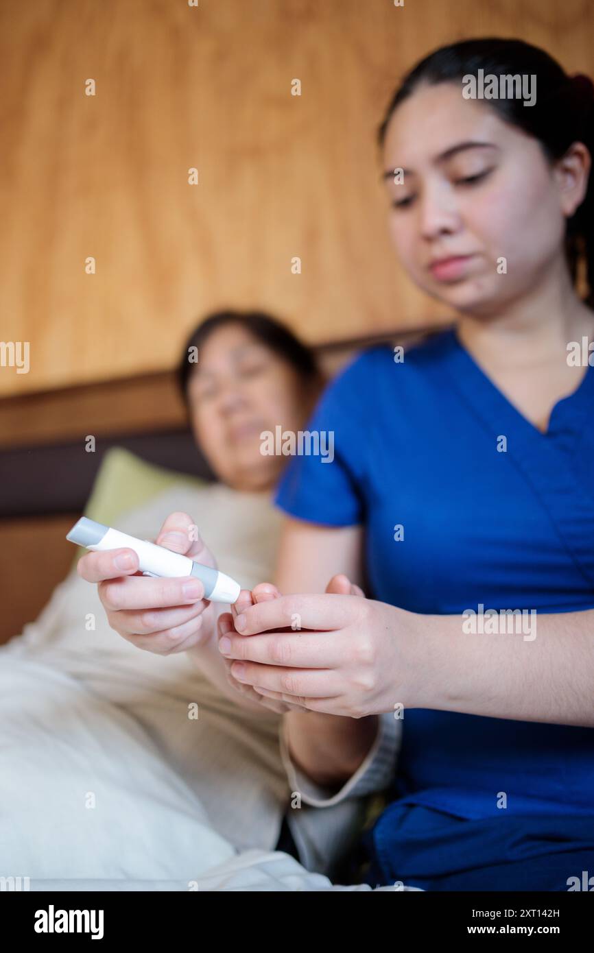 A healthcare worker is carefully conducting a blood glucose test on an ...