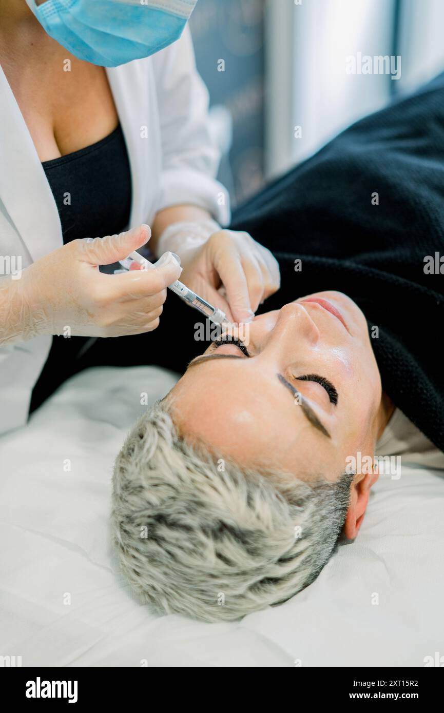 A skilled practitioner performs an injection procedure on a patient's ...