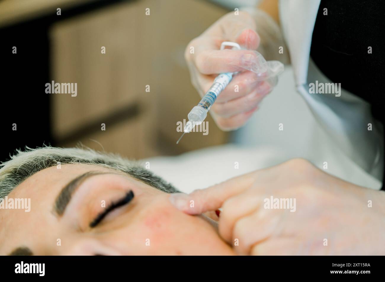 A professional esthetician administers a facial injectable treatment at ...