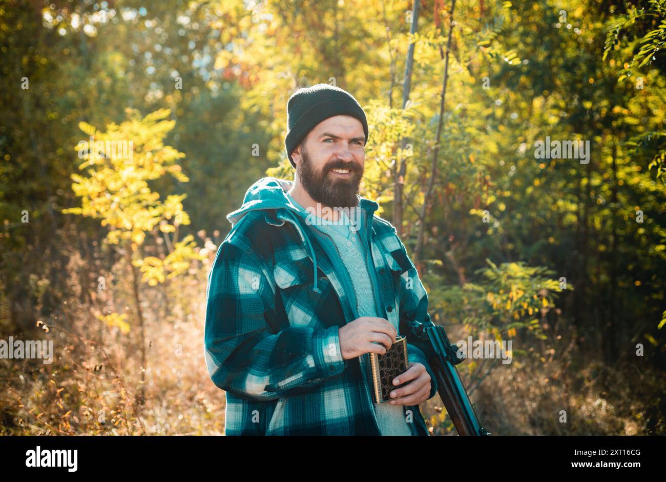 Hunter with shotgun gun on hunt. Bearded hunter man holding gun and ...
