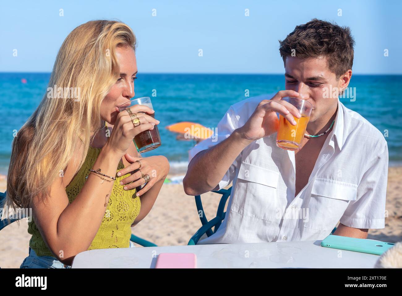 Happy young couple on vacation, drinking at a beach restaurant Stock ...