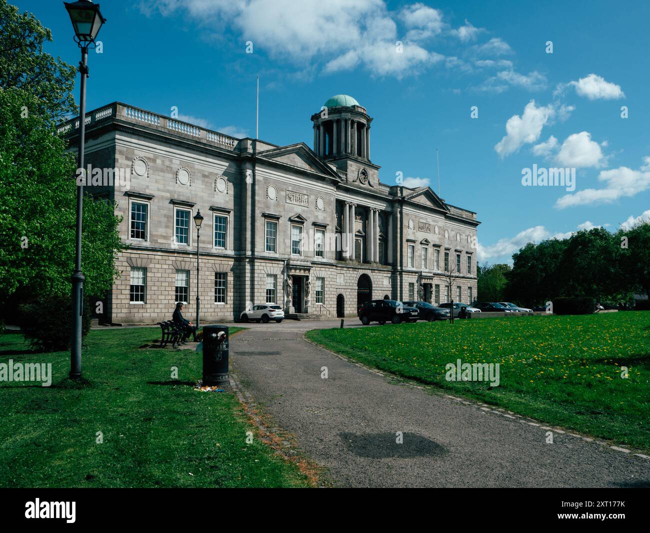 A grand historical building stands proudly in a vibrant green park ...