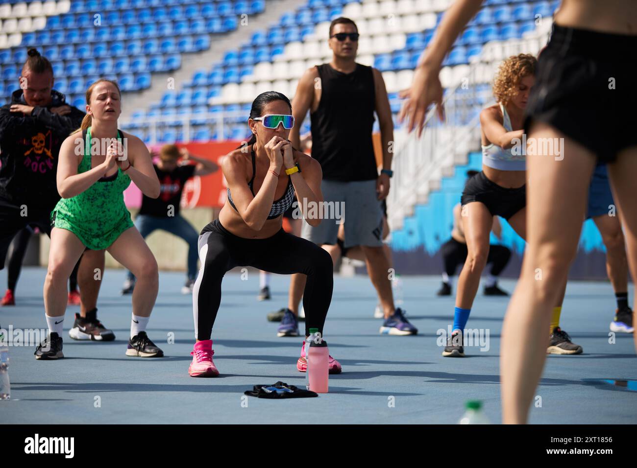 Group of people doing squat exercise at functional training in summer ...