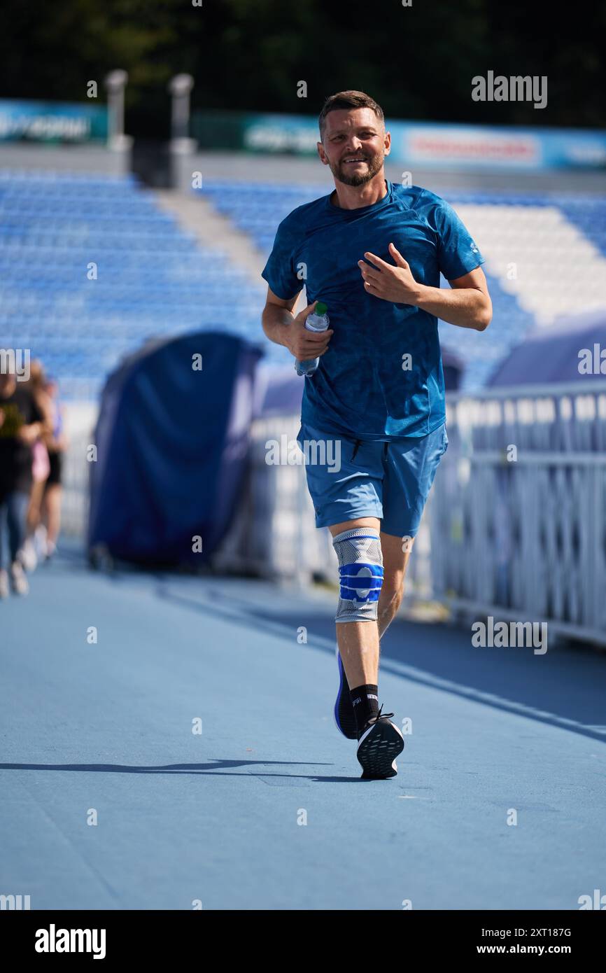Ukrainian man running a distance during open workout at stadium in Kyiv ...