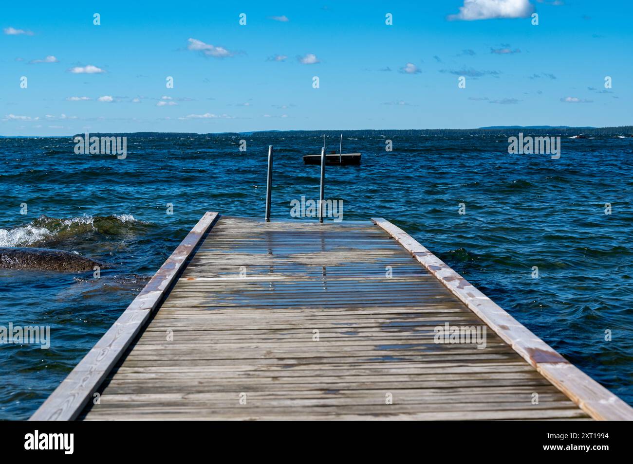 Wooden jetty with bathing ladder and floating jetty in lake Stock Photo ...