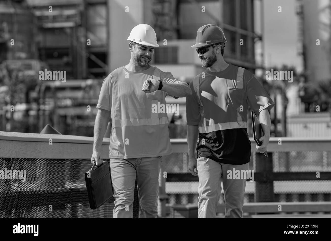 Industrial workers outdoors. Engineers in safety uniform and helmet on ...