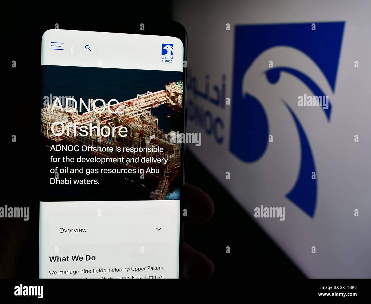 Person holding smartphone with web page of oil business Abu Dhabi ...