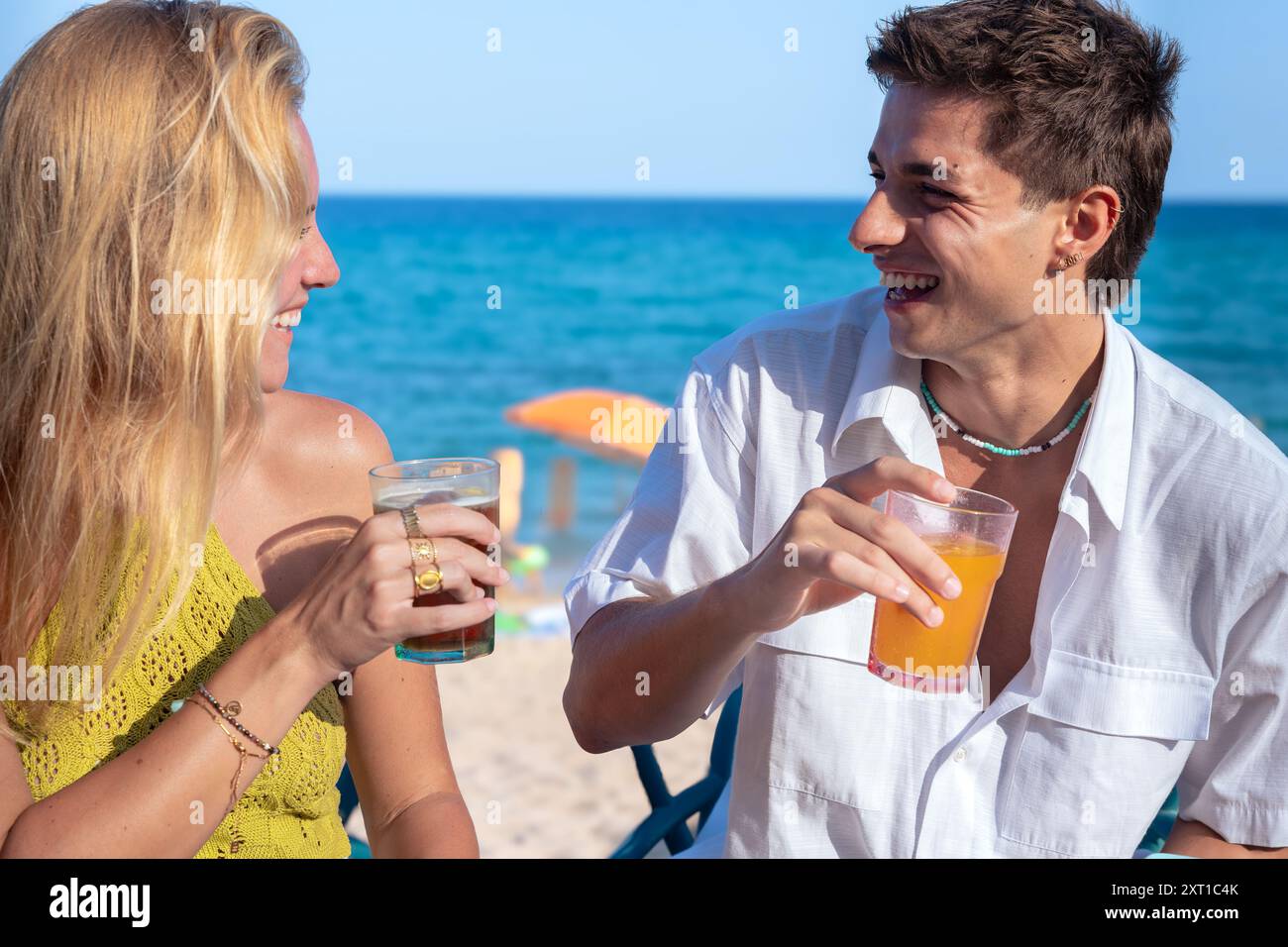 Happy young couple on vacation,drinking in restaurant Stock Photo - Alamy