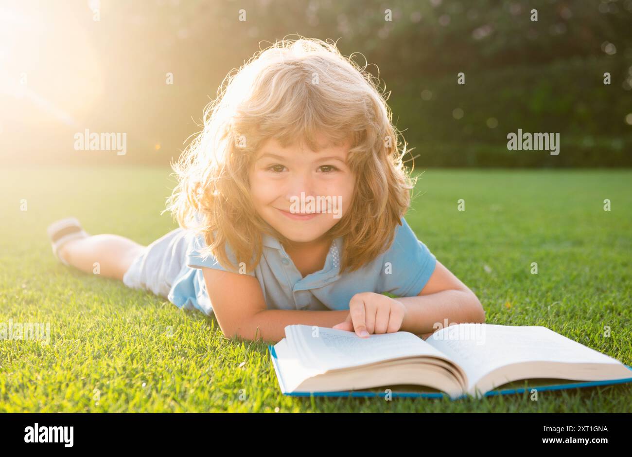 Kid boy reading interest book in the garden. Summertime fun. Cute boy ...