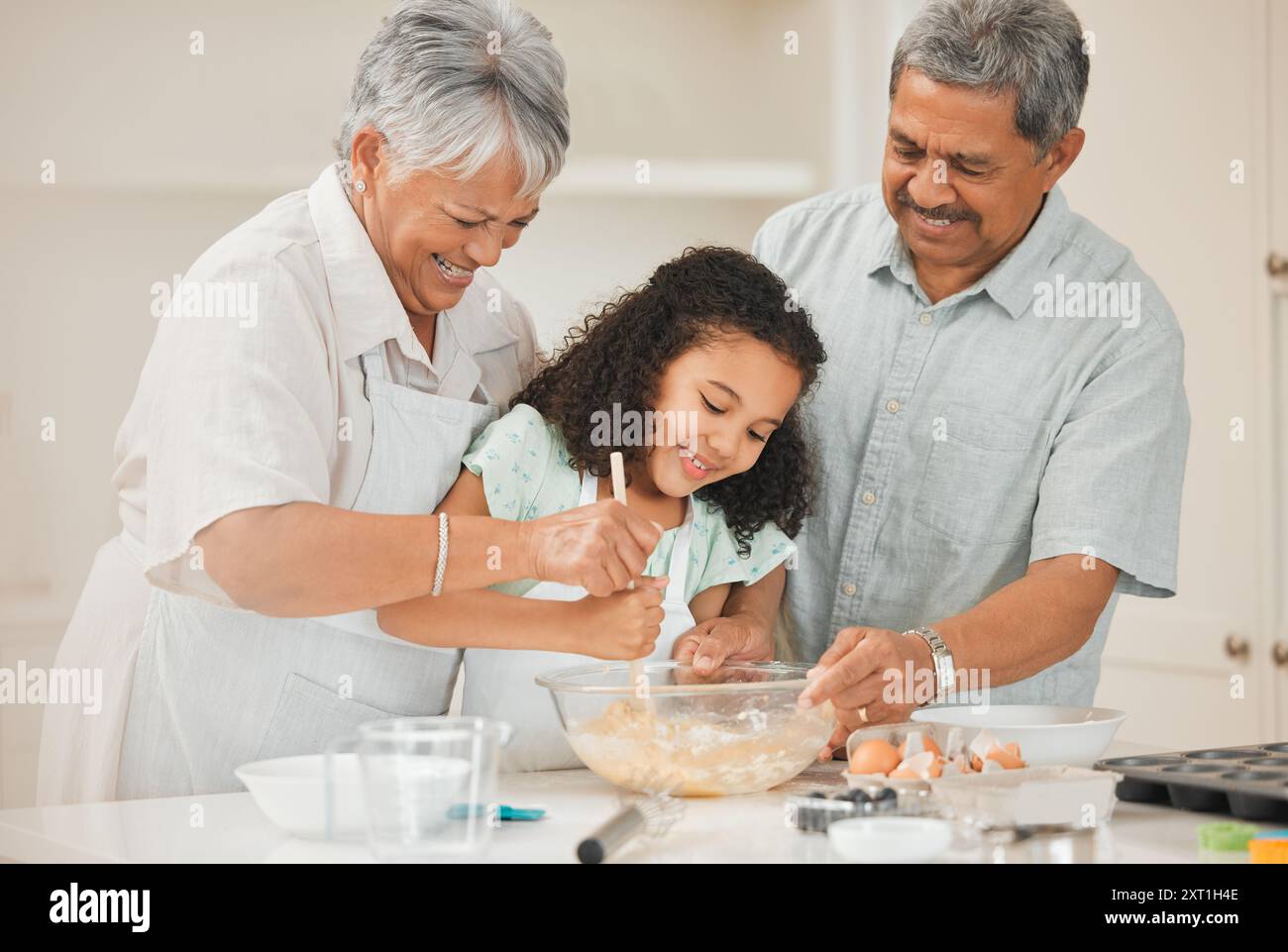 Teaching, child and grandparents with baking in kitchen for helping ...