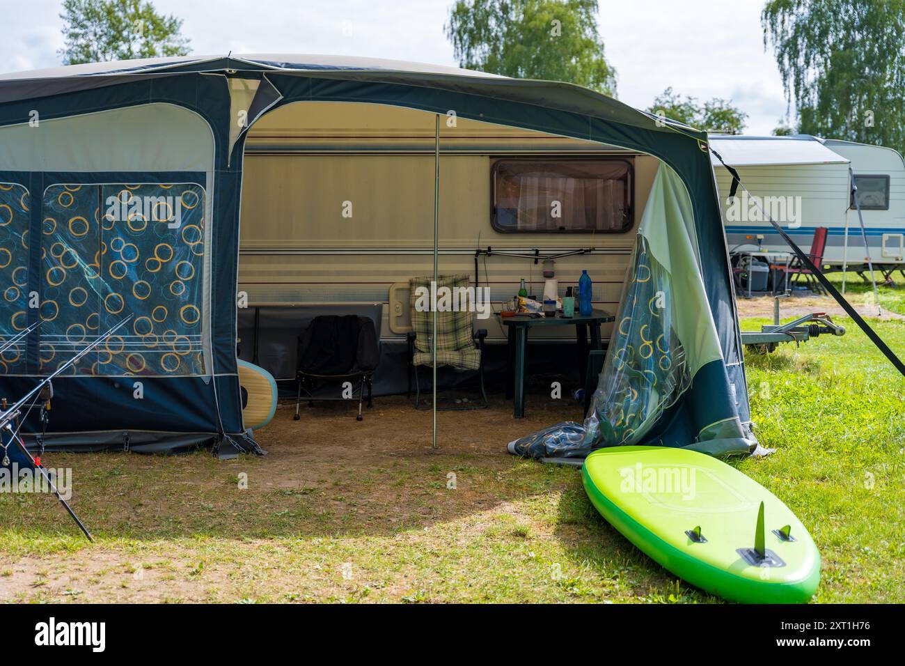 Camping setup with caravan and paddleboard at Czech riverside in summer ...
