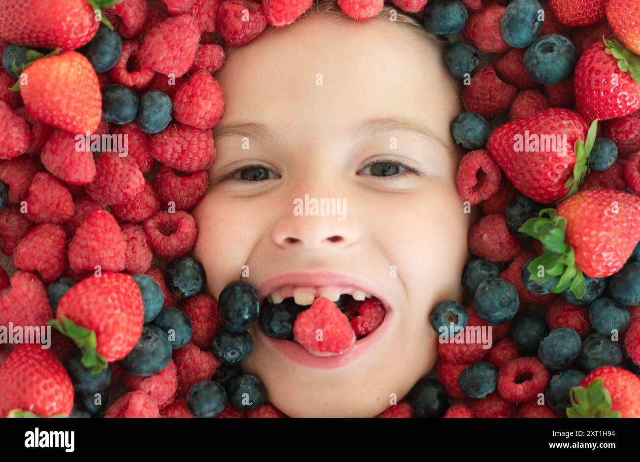 Vitamins from berrie. Kids face with fresh berries fruits. Assorted mix ...