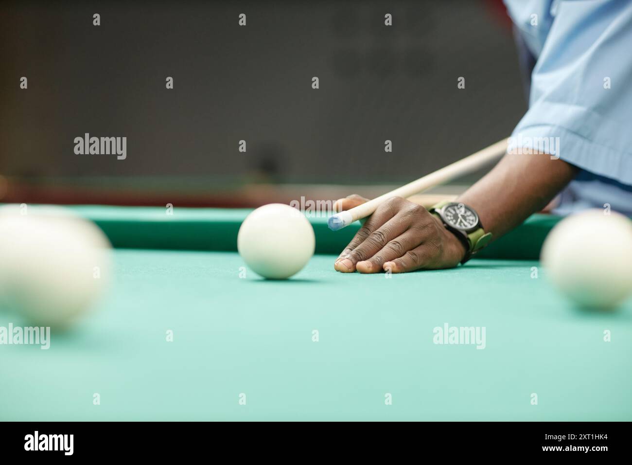 Hand holding billiard cue aiming at cue ball on pool table with other ...