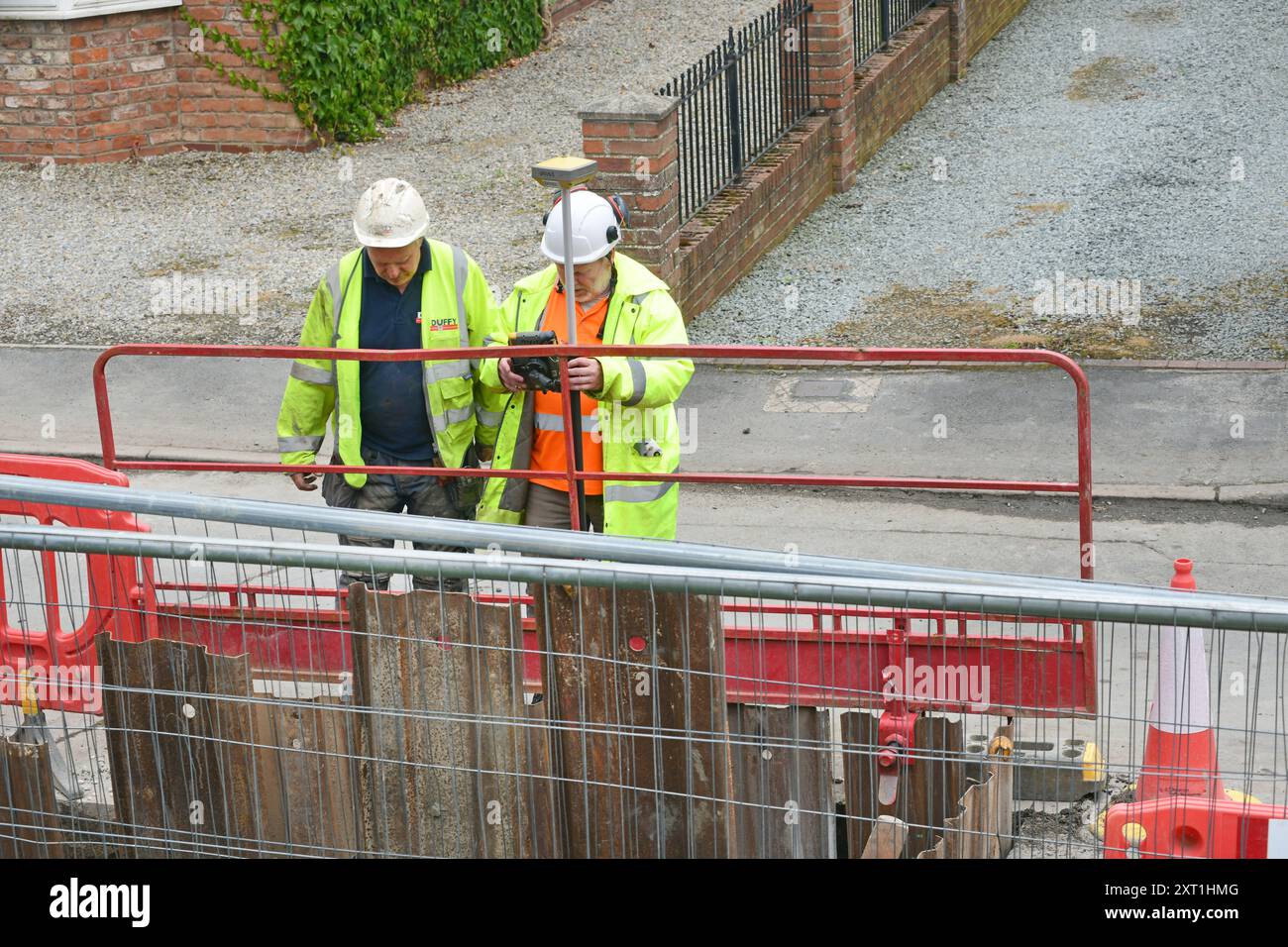 surveyor using theodolite while installing new pipe line beneath high ...