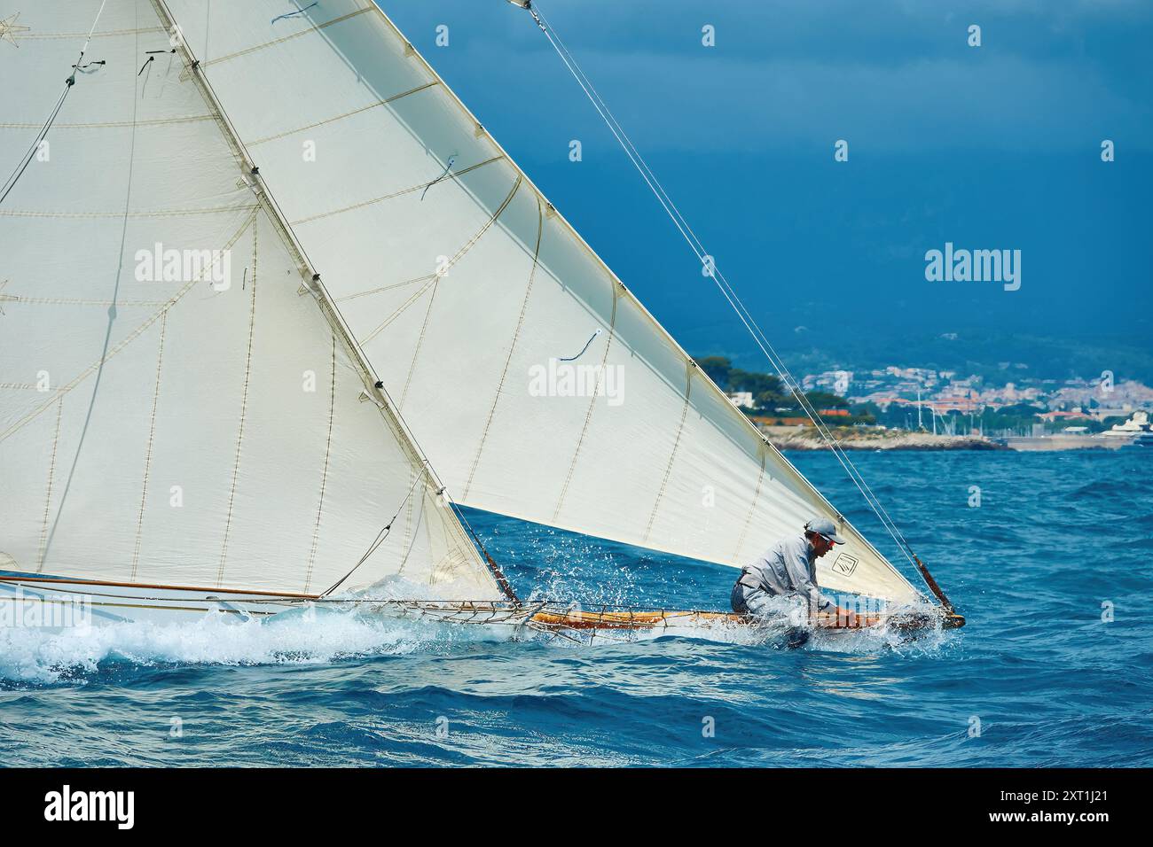 Vintage Sailboat on Vibrant Waters with Active Sailor Adjusting Rigging ...
