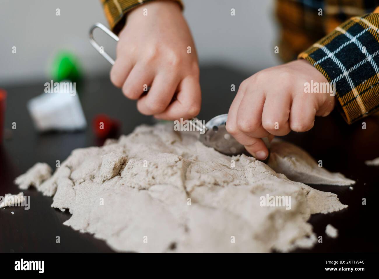 Cute boy plays in the sandbox at home. A child makes sand molds Stock ...