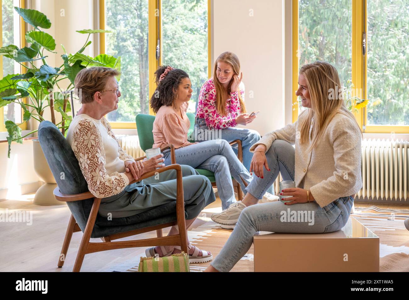 A group of women and girls of different ages engaging in conversation ...