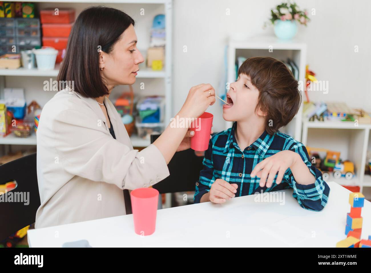 Cute woman speech therapist teaches child to pronounce words sounds and ...