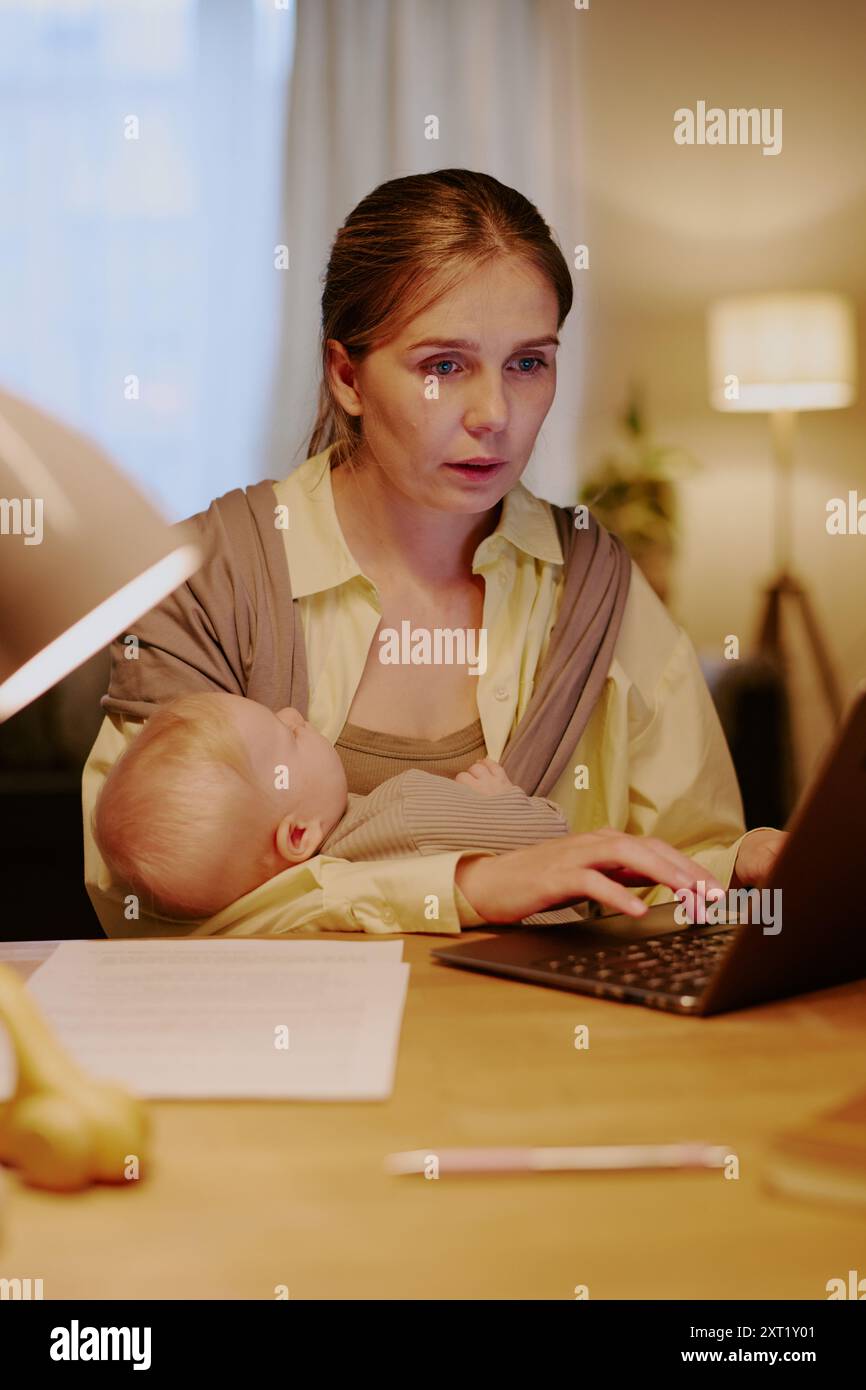 Working Mother Juggling Childcare and Professional Duties at Home Stock ...