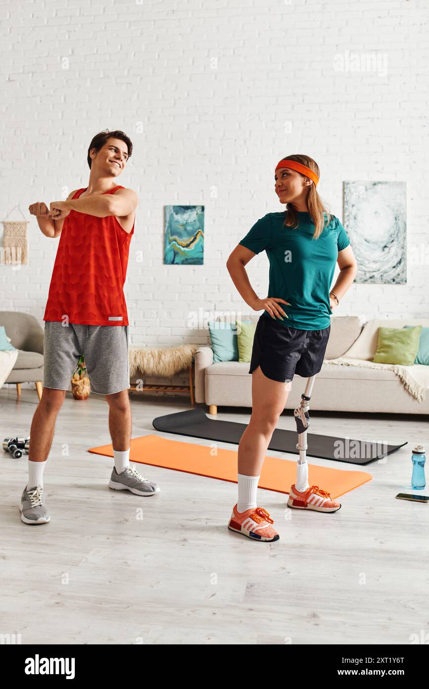 A woman with a prosthetic leg exercises with her boyfriend in a bright ...