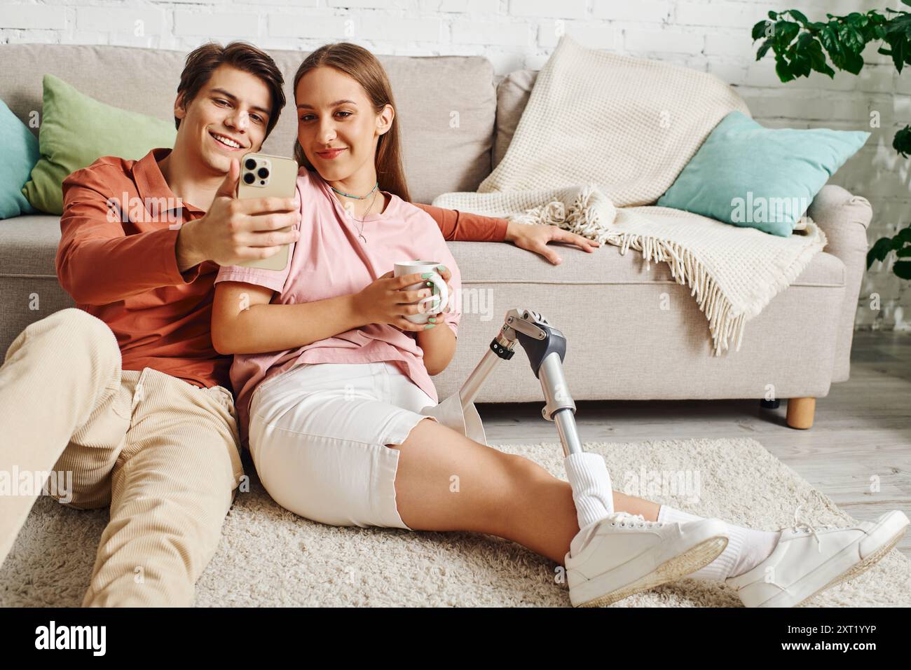 Young woman with prosthetic leg and boyfriend take selfie in living ...