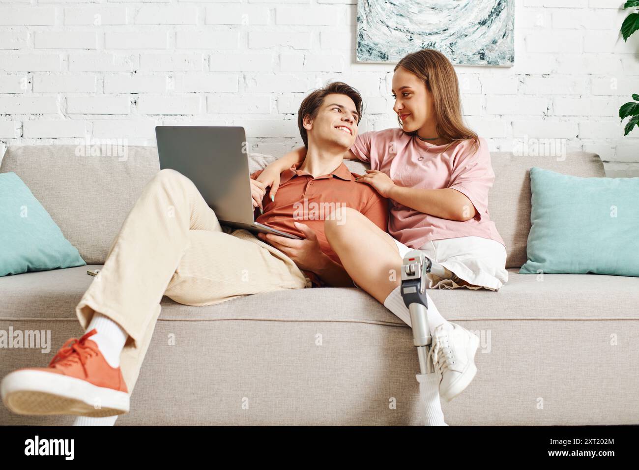 Couple on couch, woman with prosthetic leg, sharing intimate moment ...