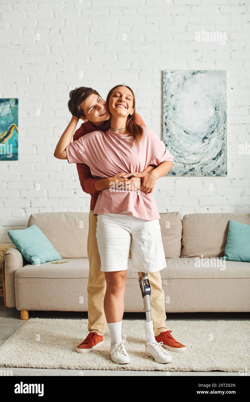 A woman with a prosthetic leg embraces her boyfriend in a living room ...