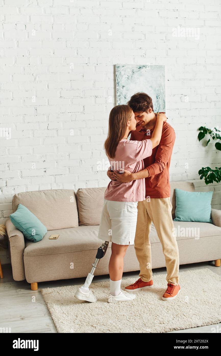 A woman with a prosthetic leg embraces her boyfriend in a living room ...
