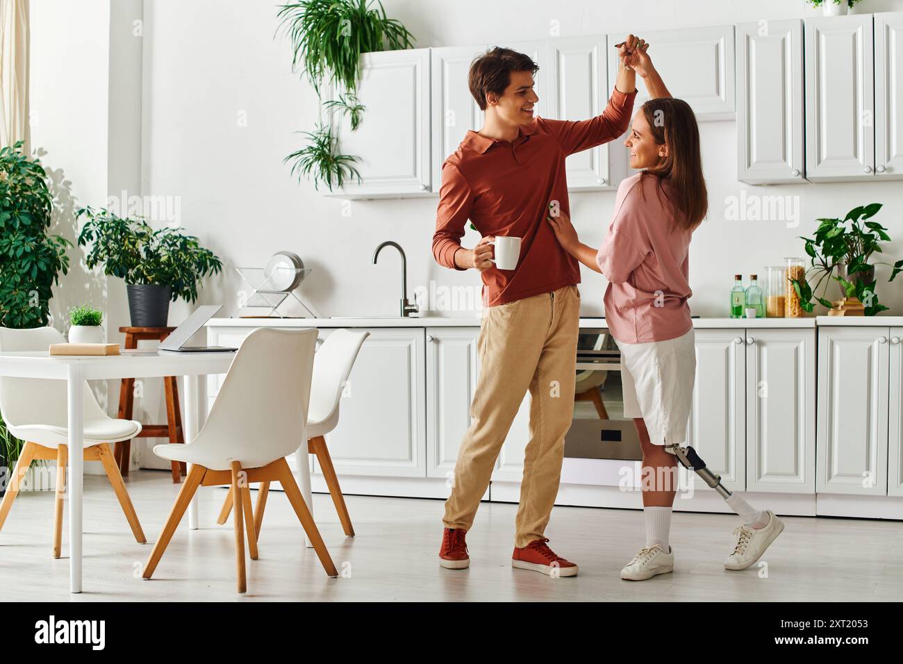 A couple dances in their kitchen, the woman with a prosthetic leg Stock ...