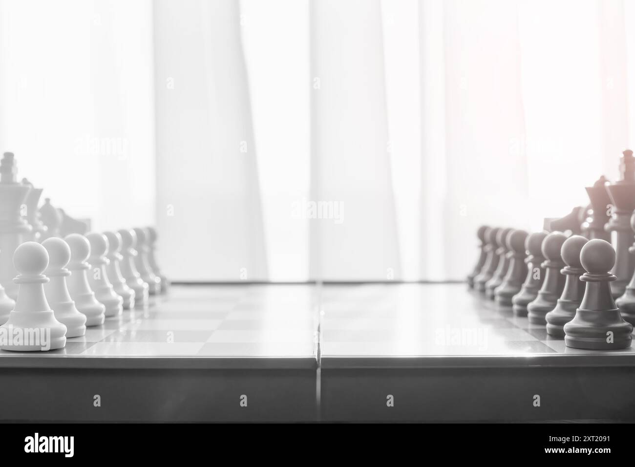A close up of chess pieces on a board with a blurred background of ...