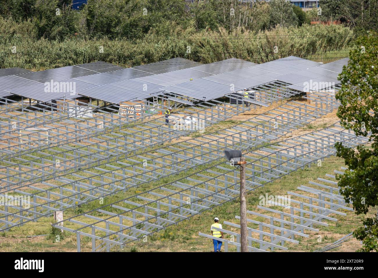 Workers are installing solar panels in a solar farm, creating renewable ...