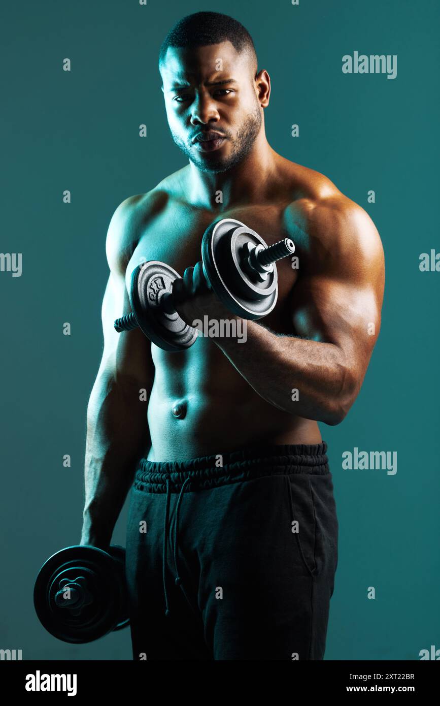Portrait, black man and dumbbell for bodybuilder in studio background ...
