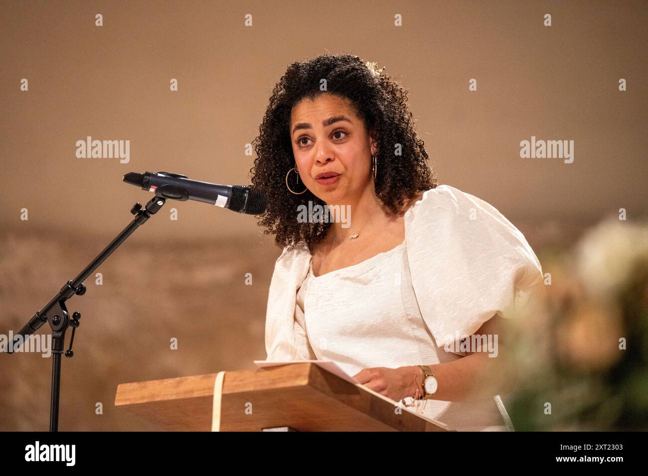 Woman giving a speech at a podium with a microphone, displaying an ...