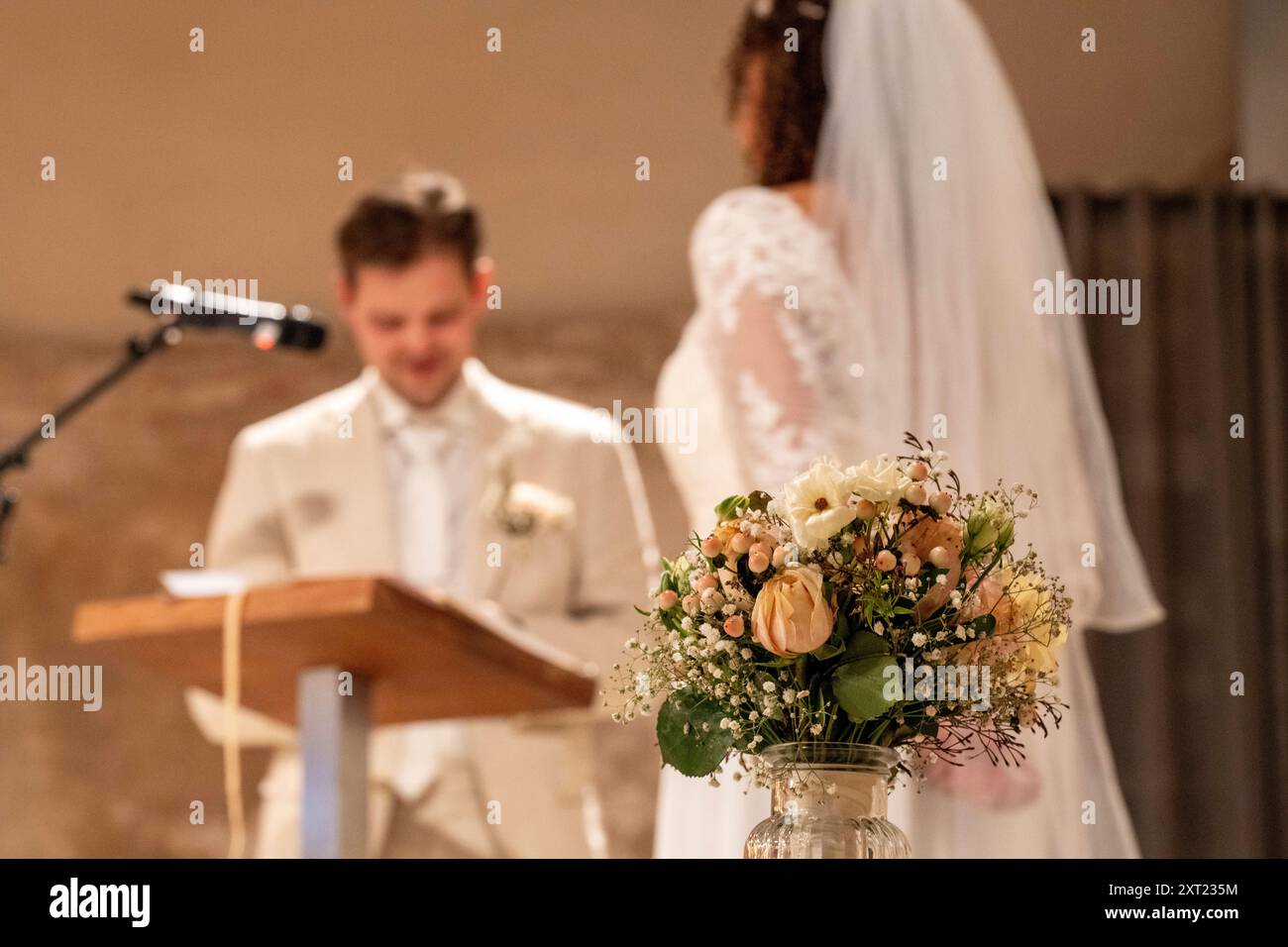 A bride and groom stand at the altar during their wedding ceremony ...