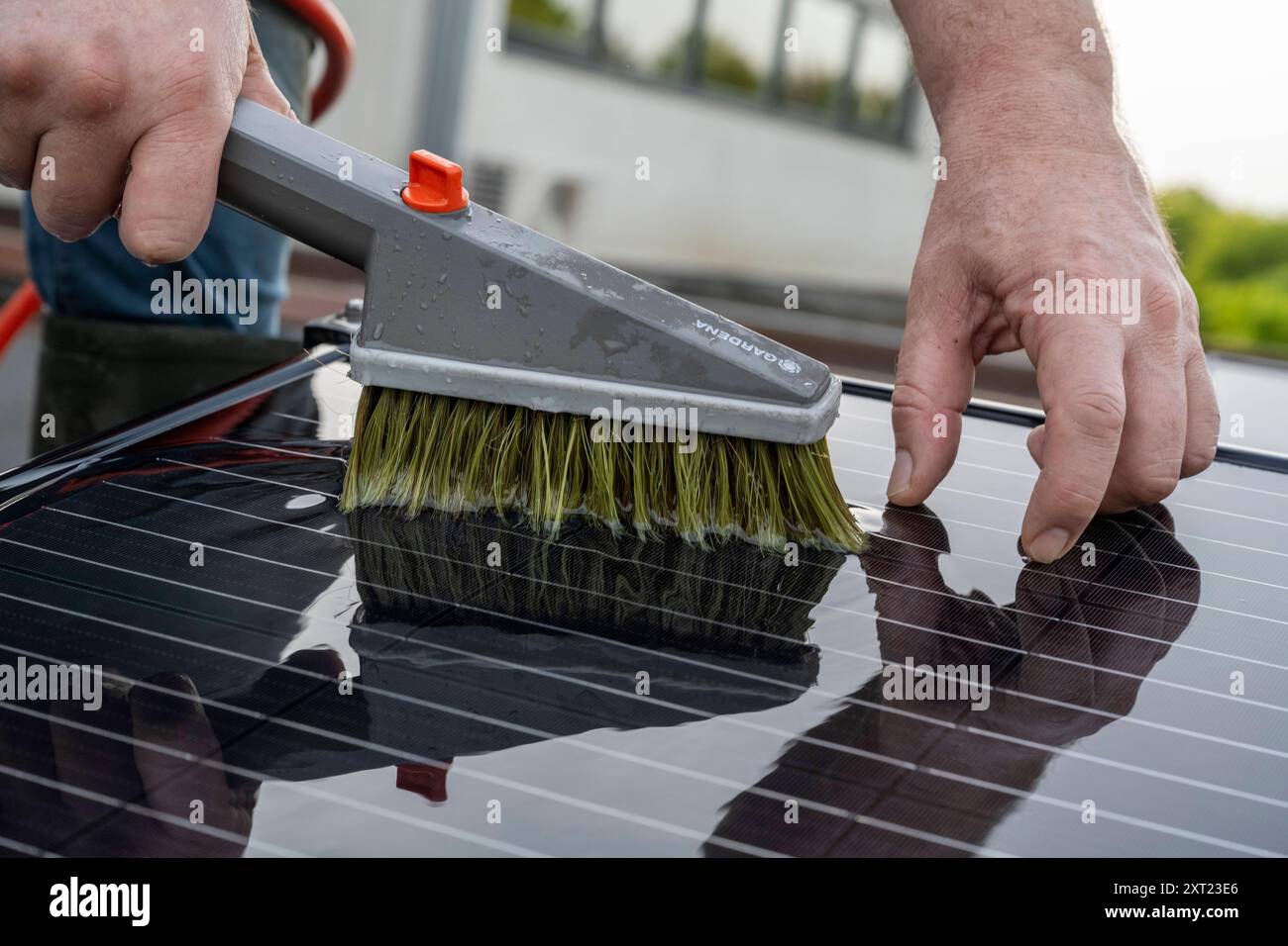 Zonnenpanelen op plat dak woonhuis reinigen Close-up of hands using a ...