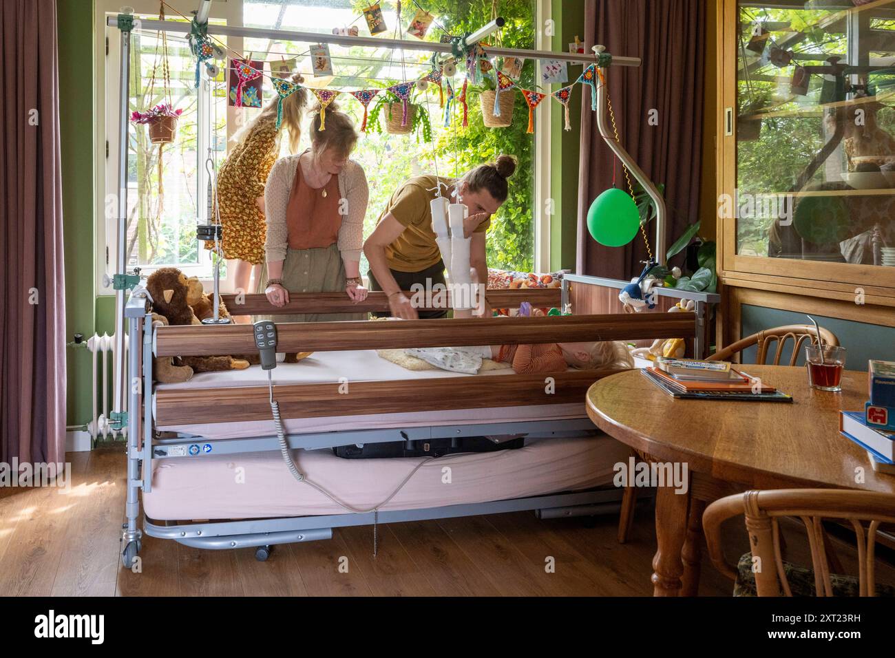 Parents attending their child who has broken their legs. Laying in bed ...