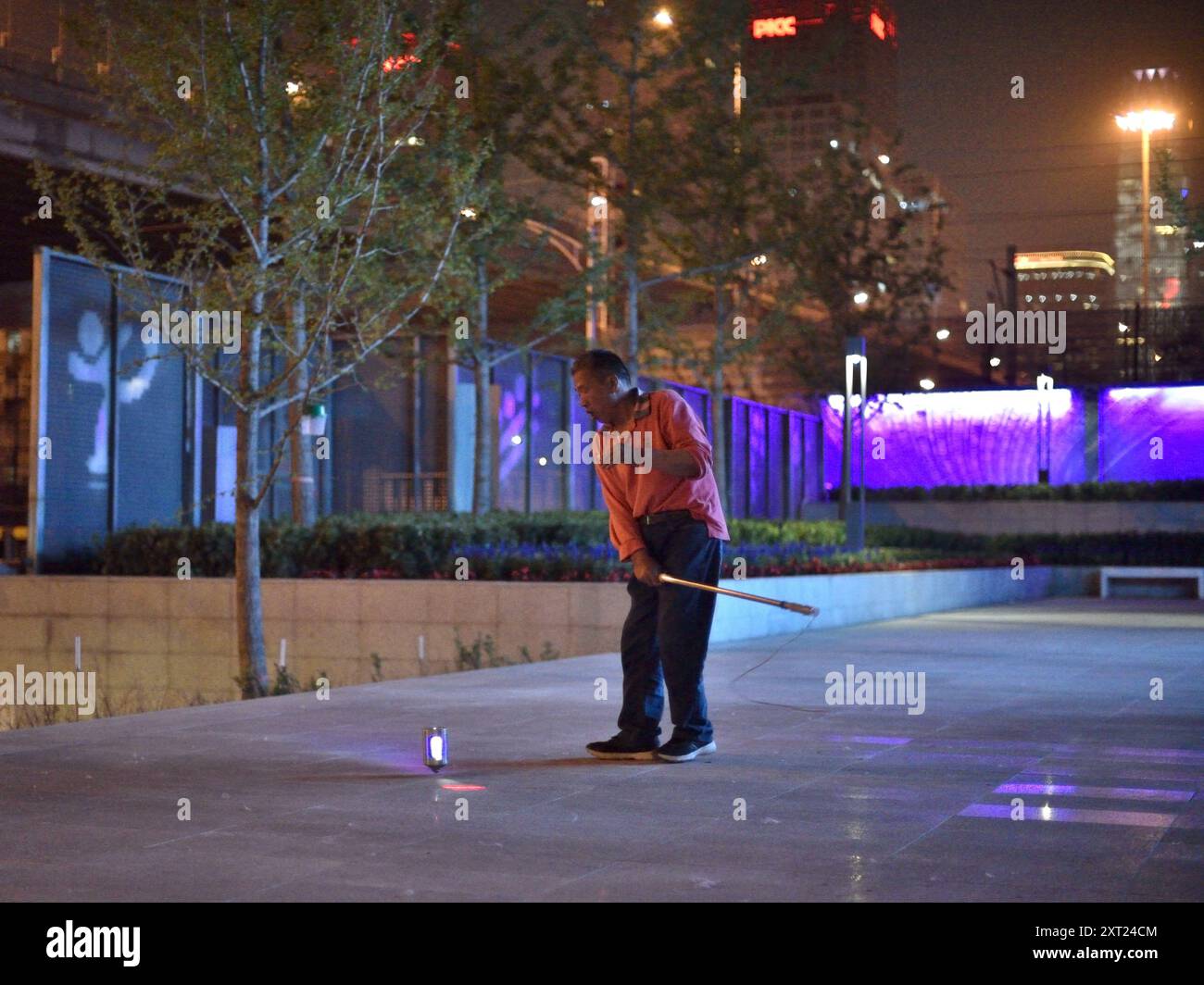 Chinese man whipping spinning tops, a traditional Chinese game in which ...