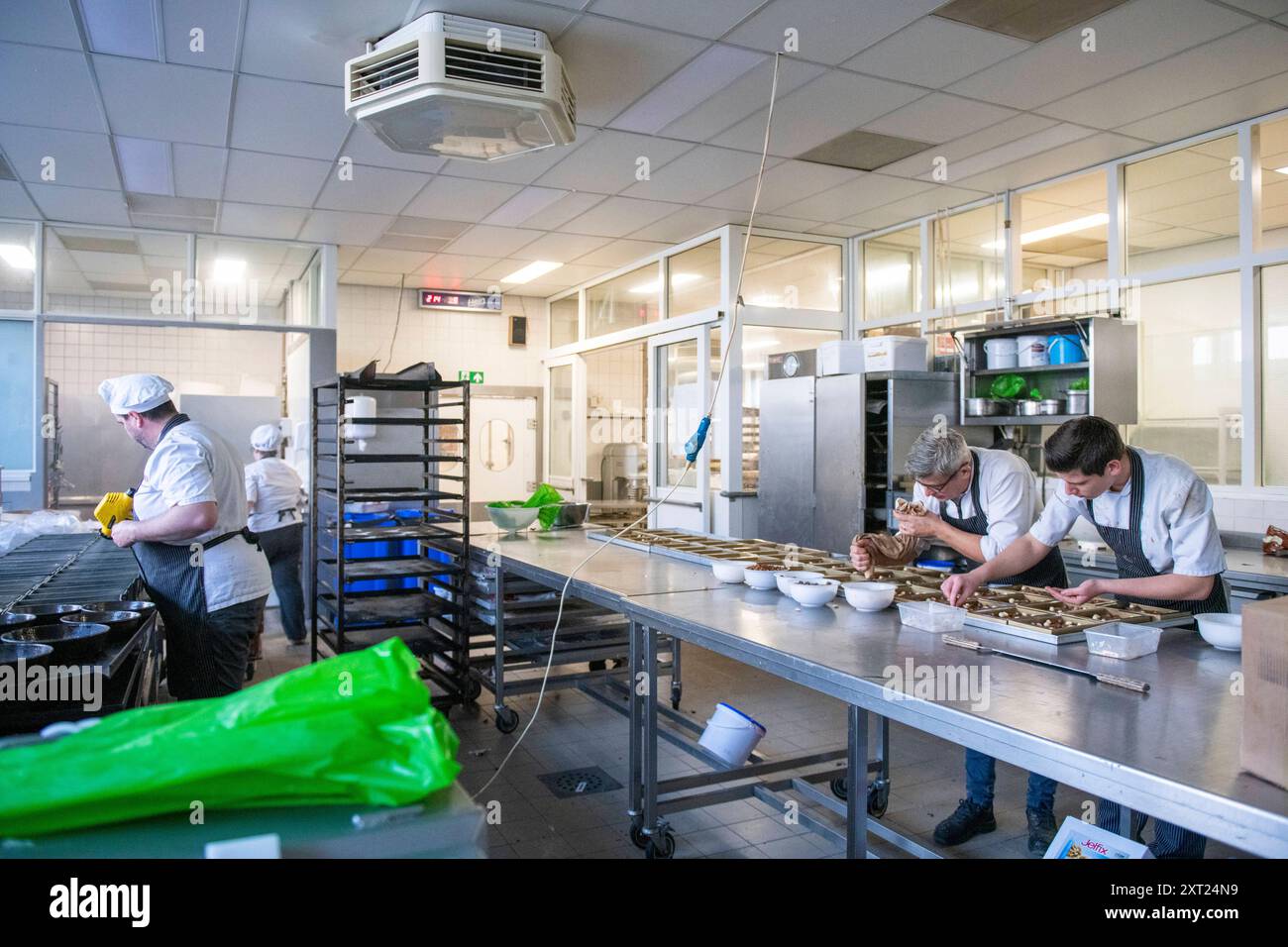 banketbakkerij Chefs preparing food in a bustling commercial kitchen ...