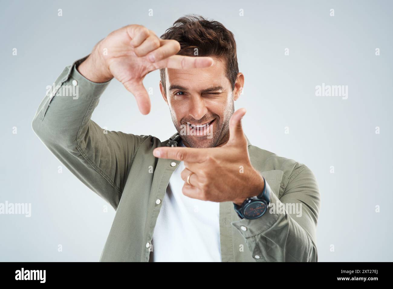Hand frame, smile and portrait of man in studio with sign for photo ...
