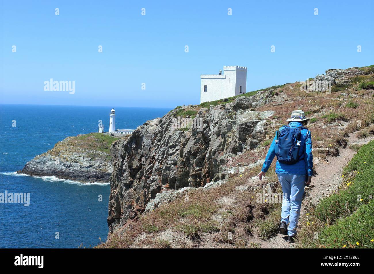 Walker on the Anglesey Coastal Path near Elin's Tower (Tŵr Elin), with ...